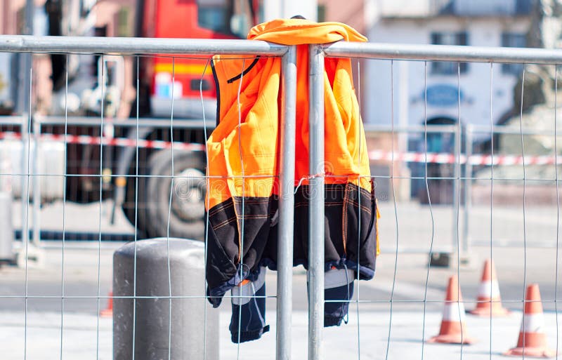 Orange Work Jacket Near on Fence on Working Area Background, Selective ...