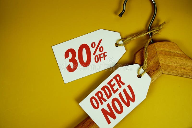 Order Now and Sale 30 on Price Tag with Wooden Clothes Hanger on Yellow ...