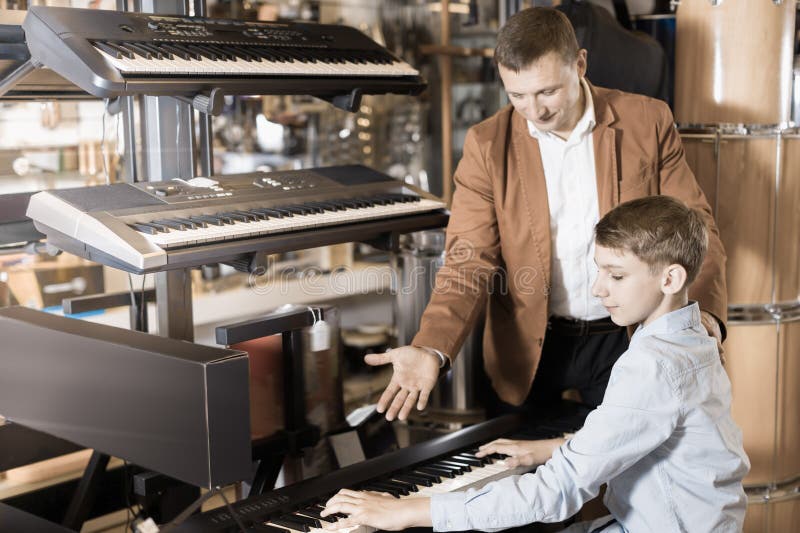 Ordinary Boy and Father Deciding on Synthesizer Stock Image - Image of ...
