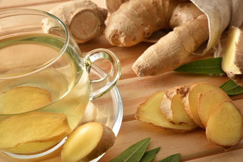 Organic Ginger Infusion and Sliced Ginger Root on Wooden Table Stock ...