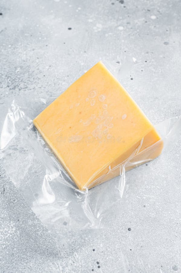 Organic Sharp Cheddar Cheese in Vacuum Packaging. Gray Background Stock ...