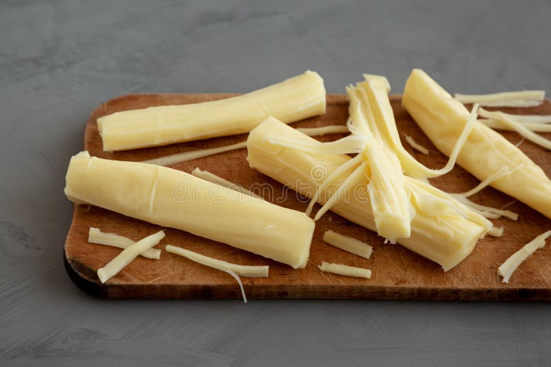 Organic String Cheese on a Rustic Wooden Board on a Gray Background ...