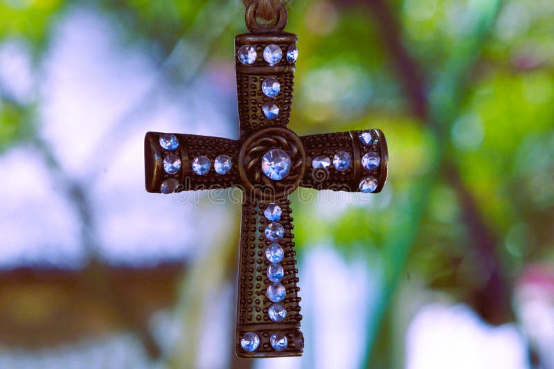 An Ornamental Cross Hanging on a Rope. Stock Image - Image of blurred ...