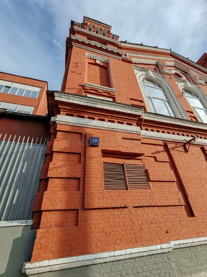 An Ornate Red Brick Structure with Arched Windows, White Decorative ...