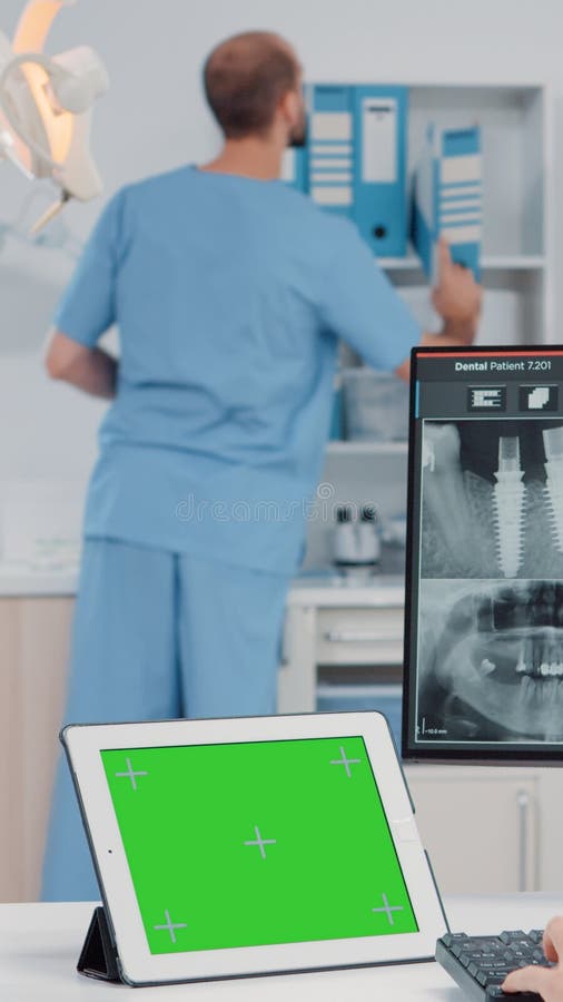 Orthodontist Using Horizontal Green Screen on Tablet Stock Photo ...