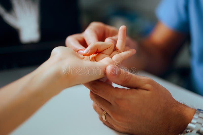Orthopedic Specialist Testing the Patient Fingers in a Clinic Stock ...
