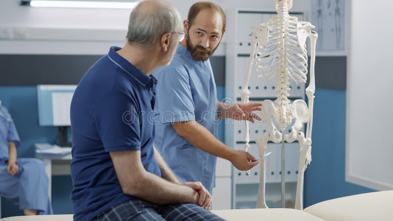 Osteopathy Specialist Explaining Spinal Cord System on Human Skeleton ...