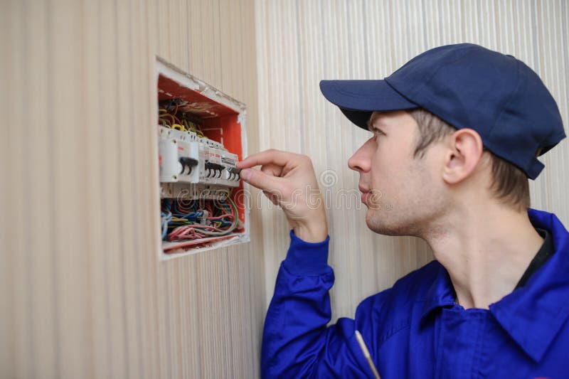 Oung Electrician in Blue Overall Disassembling a Electrical Panel Stock ...