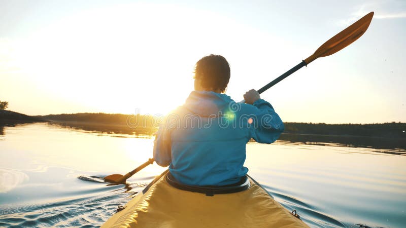 Outdoor Activities, Man is Kayaking on Calm Lake Against Sunset Rays ...
