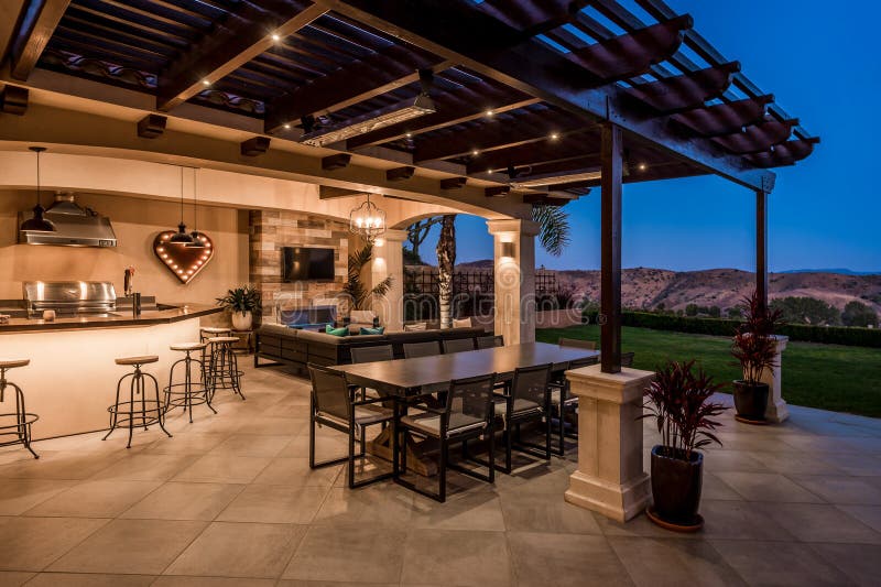 An Outdoor Bar and Dining Area is Set in Front of the Kitchen Stock ...