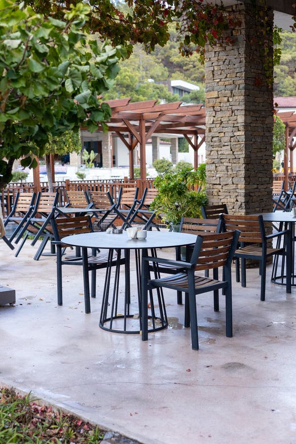 Outdoor Dining Area with Empty Tables Nestled Under Rustic Architecture ...