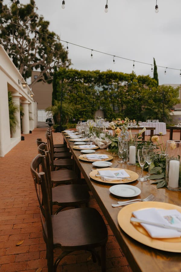 Outdoor Dining Setup with a Long Table Decorated with Plates, Glasses ...