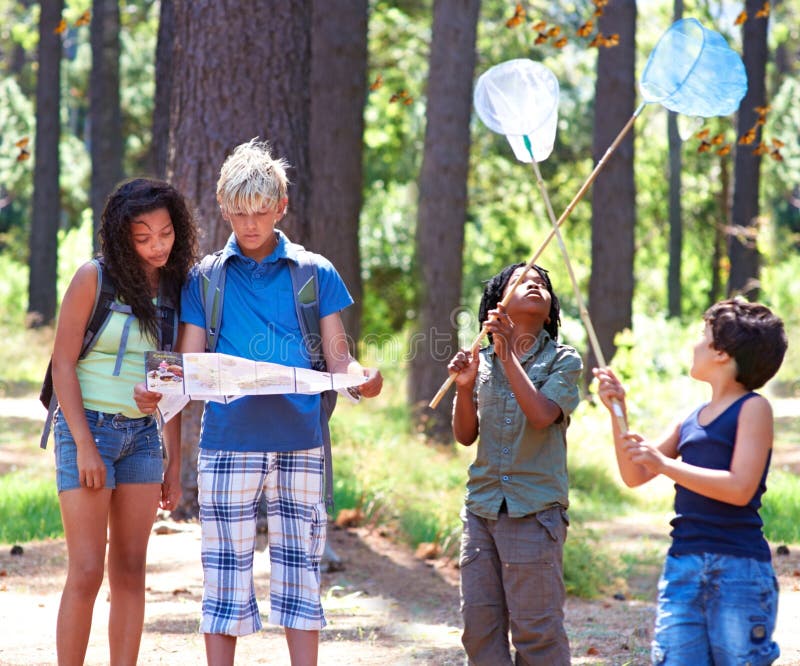 An Outdoor Experience. Multi-ethnic Kids Exploring a Map while Standing ...