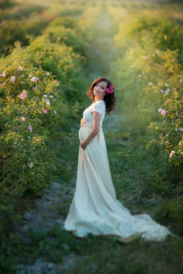 Outdoor Natural Portrait Of Beautiful Pregnant Woman In White Dress