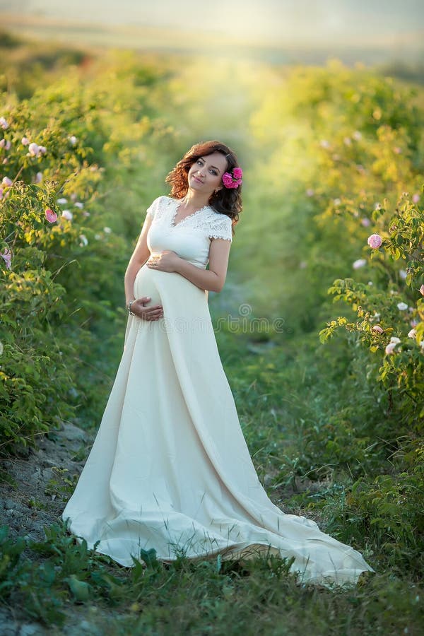 Outdoor Natural Portrait Of Beautiful Pregnant Woman In White Dress