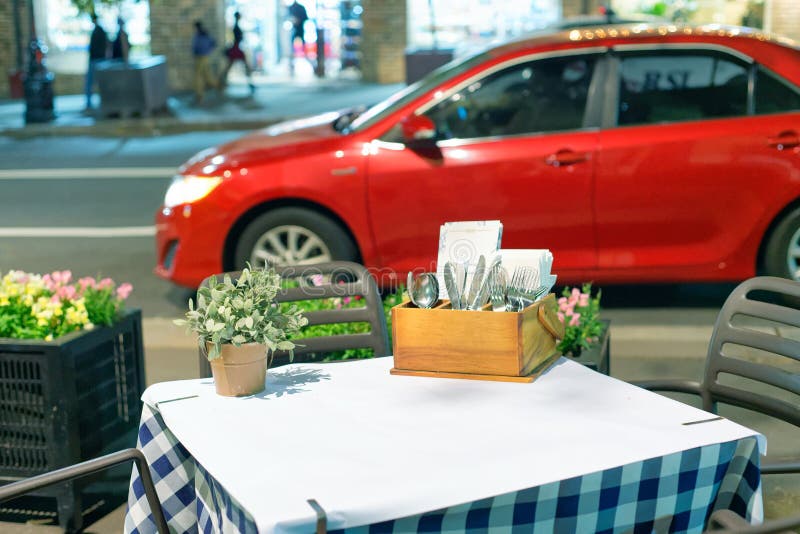 Outdoor Restaurant Table with Red Car Parked in Front Stock Photo ...