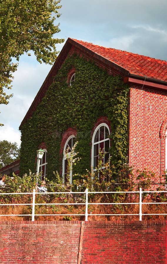 Outdoor View of a Red Brick Building with Vines Growing on the Wall ...