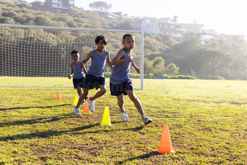 Outdoors, Running through Cones, Multiracial Boys Training on School ...