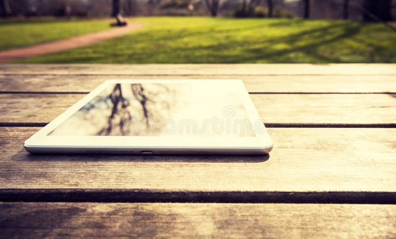 Outdoors Rustic Wooden Table with Digital Tablet, Reflecting Trees ...