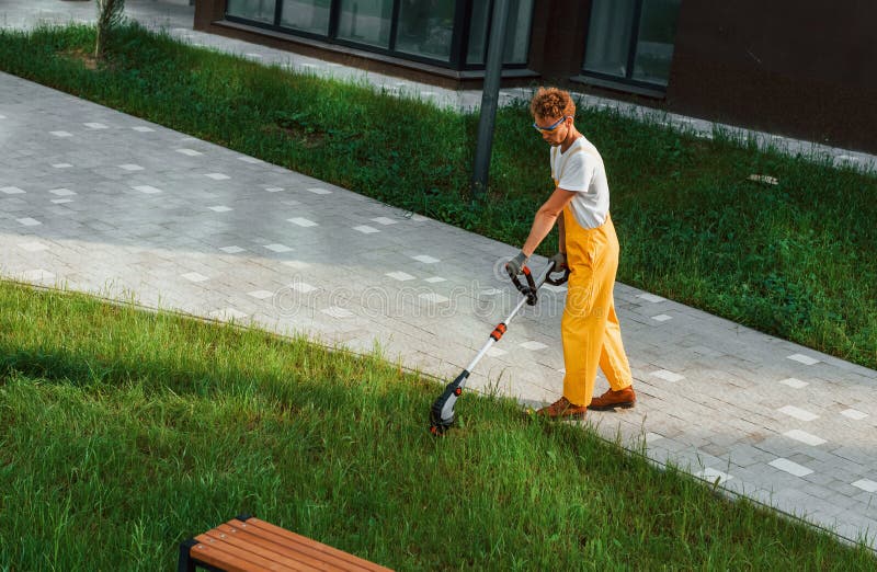 Outdoors in the Yard. Man Cut the Grass with Lawn Mover Stock Photo ...