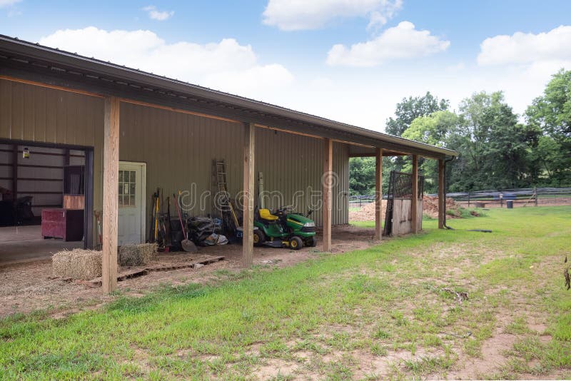 Outside View of Stable with Farm Tools and Equipment in the Yard ...