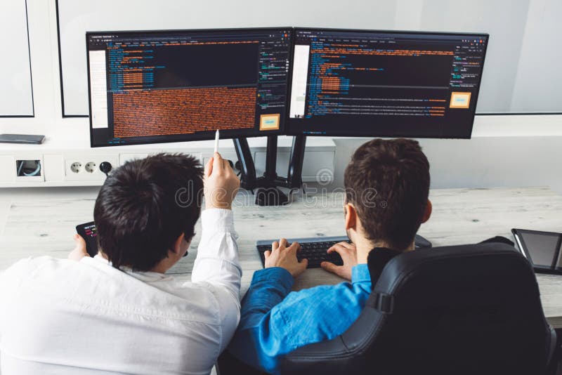 Over the Head View, Two it Gus Working on Two Screens in the Office ...