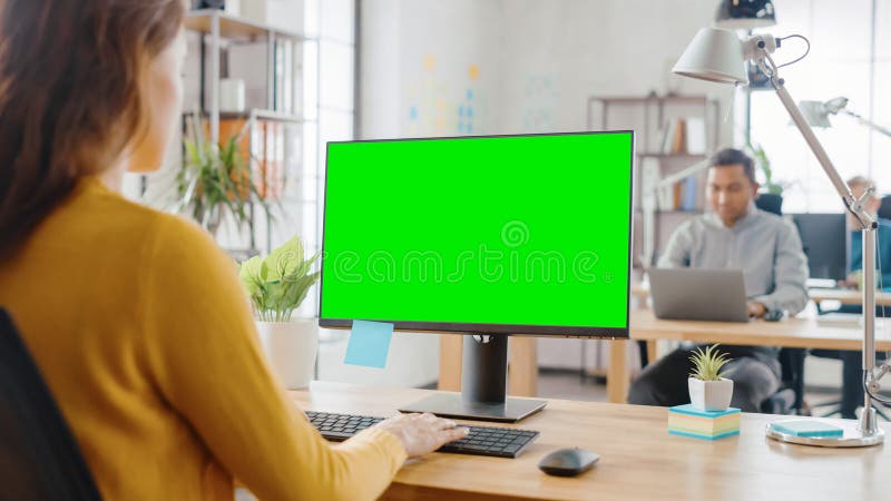 Over the Shoulder: Creative Young Woman Sitting at Her Desk Using ...