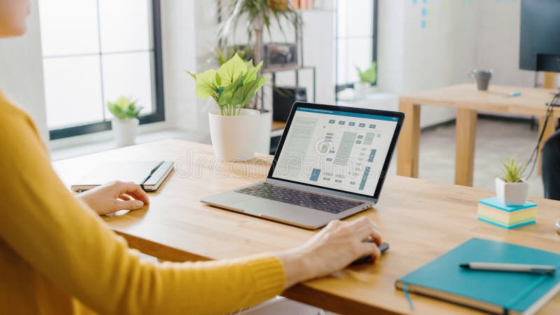 Over the Shoulder: Female Engineer Developer Sitting at Her Desk Using ...