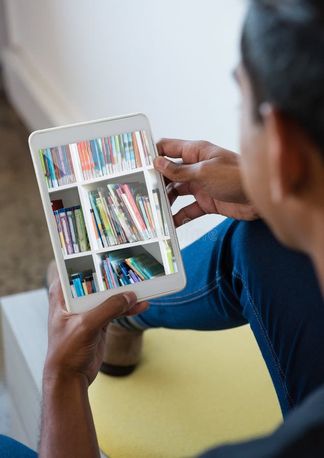 Over Shoulder View of Man Holding Tablet with Image of Books on Shelves ...