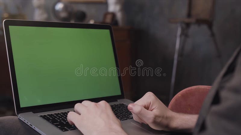 Over the Shoulder View of a Man Sitting at His Desk and Working on a ...