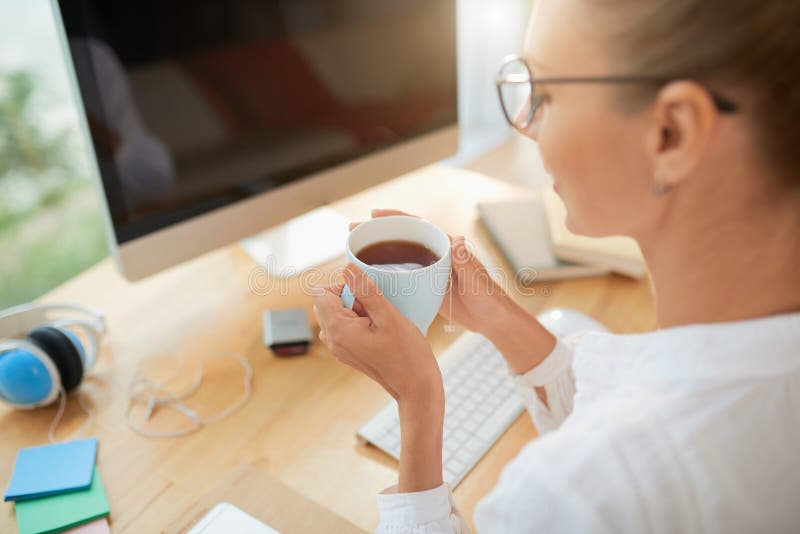 Drinking Tea at Work stock photo. Image of young, eyeglasses - 96034974