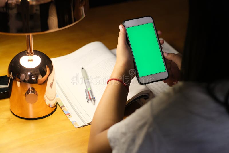 Young Woman Using Green Screen Smart Phone while Study Under Lamp Light ...