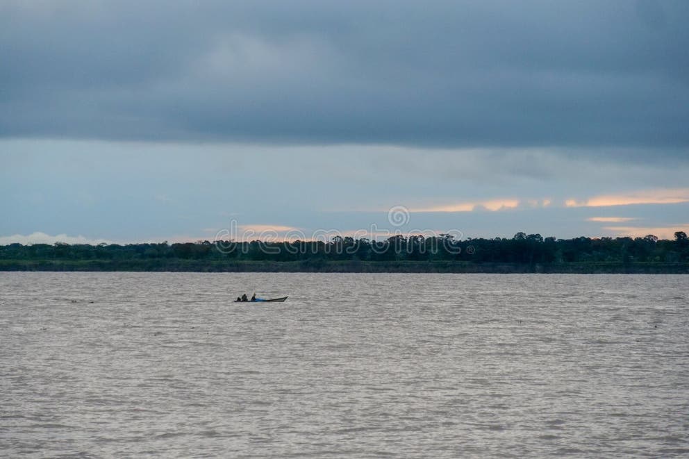 Overcast Sunset on the Amazon River in Brazil while a Small Riverboat ...