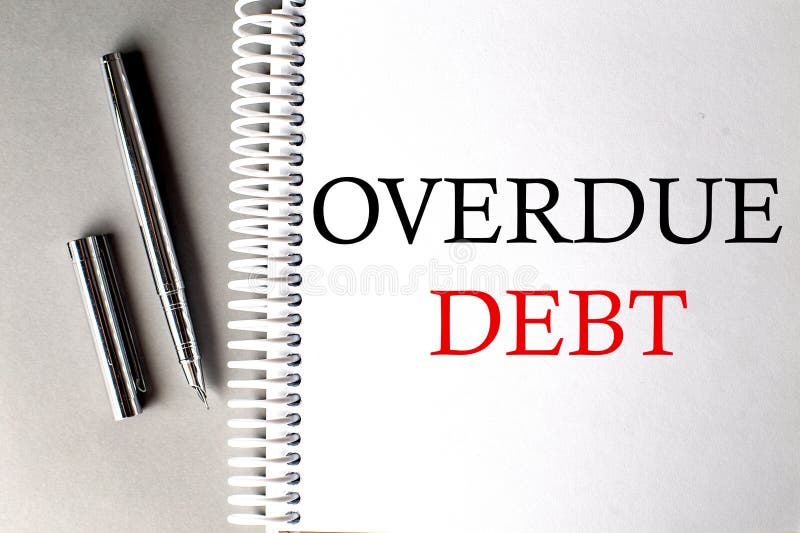 OVERDUE DEBT Text on a Notebook with Pen on Grey Background Stock Image ...