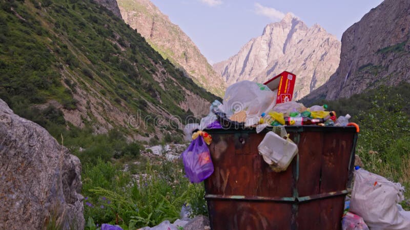 Overfilled Garbage Bin with Trash Around in the Mountains. Stock ...