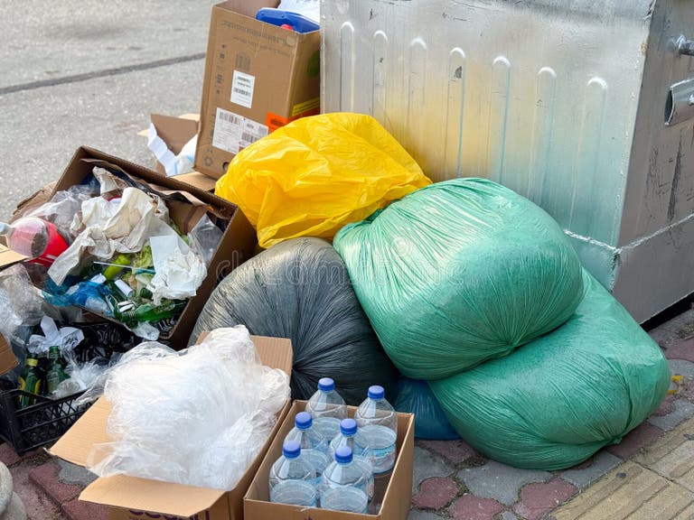 Overflowing Garbage Container with Plastic Bags and Cardboard. Urban ...