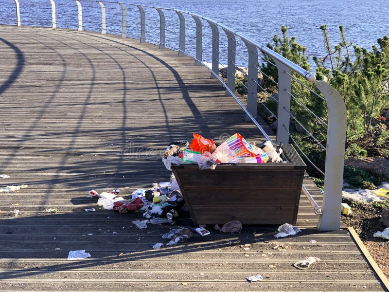Overflowing Trash Can on the Waterfront in the Recreation Area. Garbage ... Overflowing Trash Can on the Waterfront in the Recreation Area. Garbage ...
