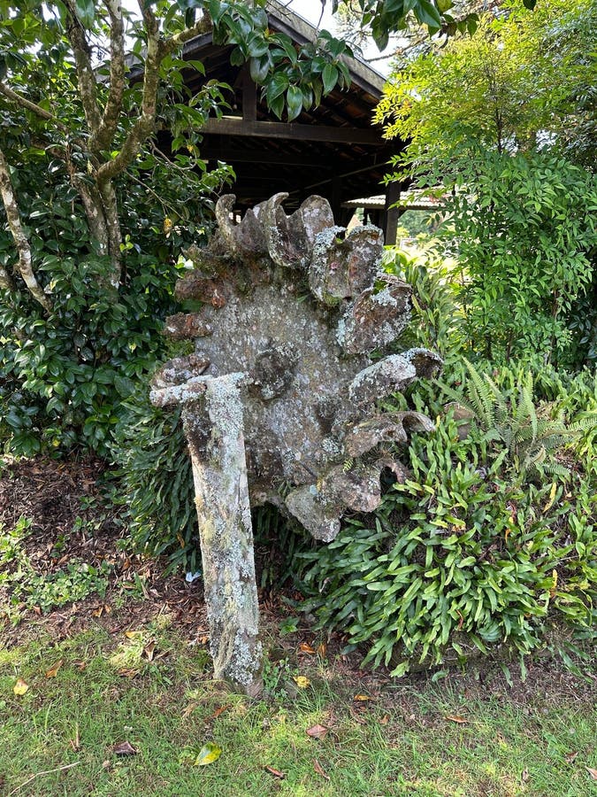 An Overgrown, Large, Circular Stone Object Resembling a Gear or Wheel ...