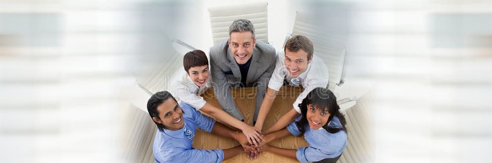 Overhead of Business Team Looking Up and Putting Hands Together at Table and Blurry White ...