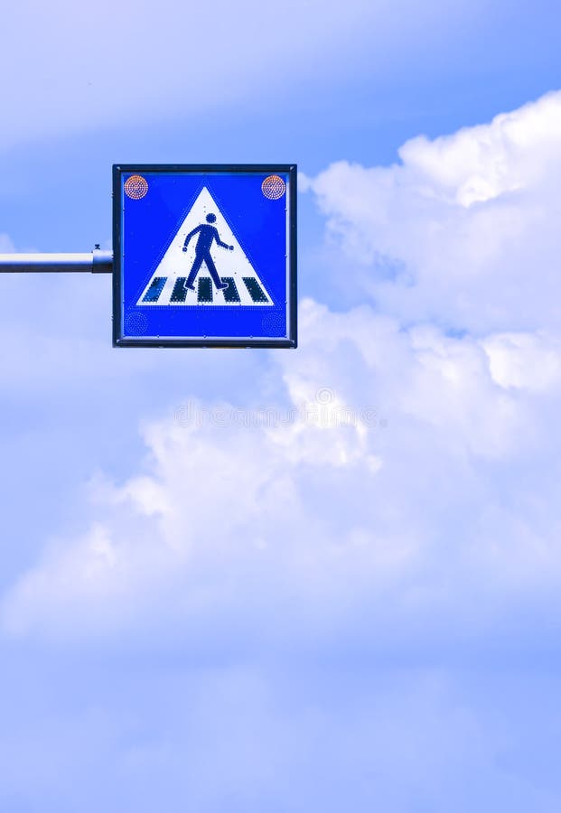 Overhead Electric Pedestrian Crossing Sign with Blurred White Cloud and ...