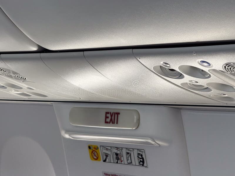Overhead Exit Sign and Ventilation Panel in Airplane Cabin Interior ...