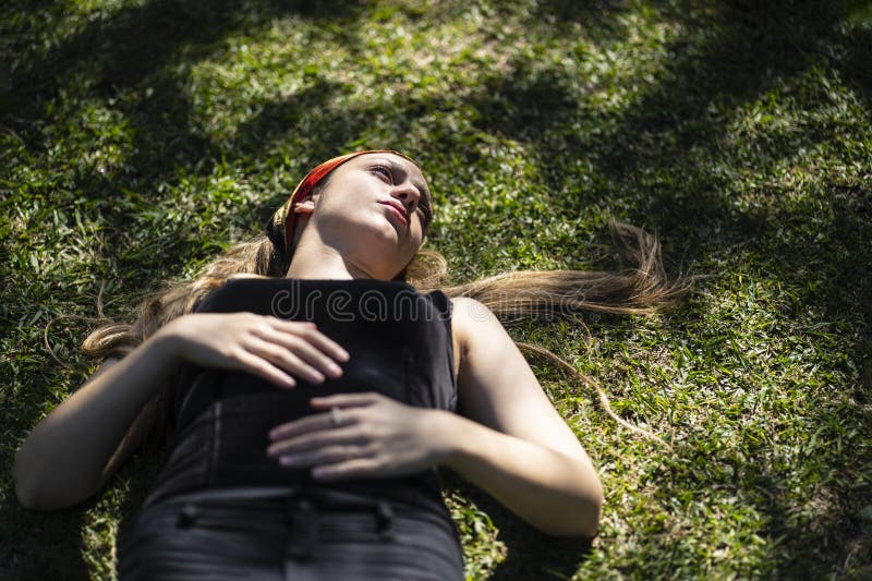 Overhead Portrait Of Blonde Woman Lying On The Grass With Lights And