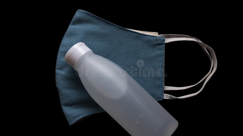 Overhead Shot of a Blue Face Mask and a Bottle of Rubbing Alcohol on a ...