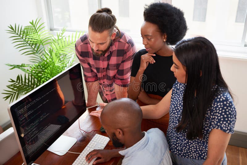 Overhead Shot of Four Developers Working Together, Reviewing Code on ...