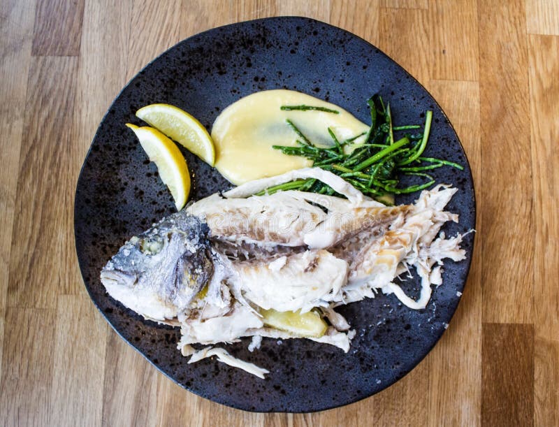Overhead Shot of a Raw Fish with Lemons on a Round Plate Stock Photo ...