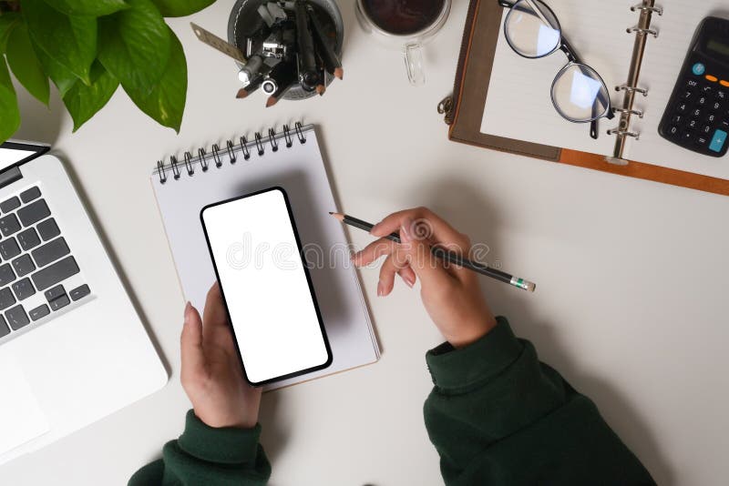 Woman Holding Mobile Phone and Making Note on Notebook. Stock Image ...