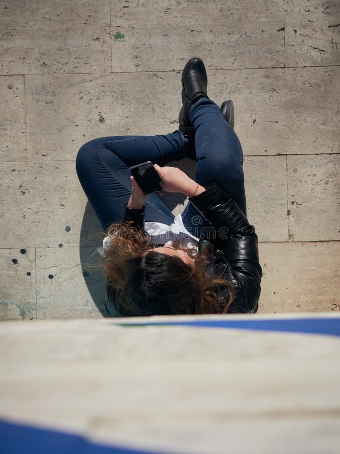 Overhead Shot of a Young Female Using Her Smartphone while Sitting on ...