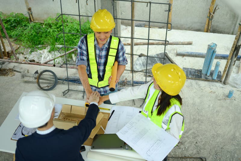 Overhead View of Contractor and Architect Team Stacking Hands Together ...