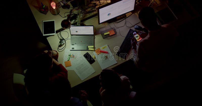 Overhead View of a Dedicated Team Working Late at Night, Surrounded by ...