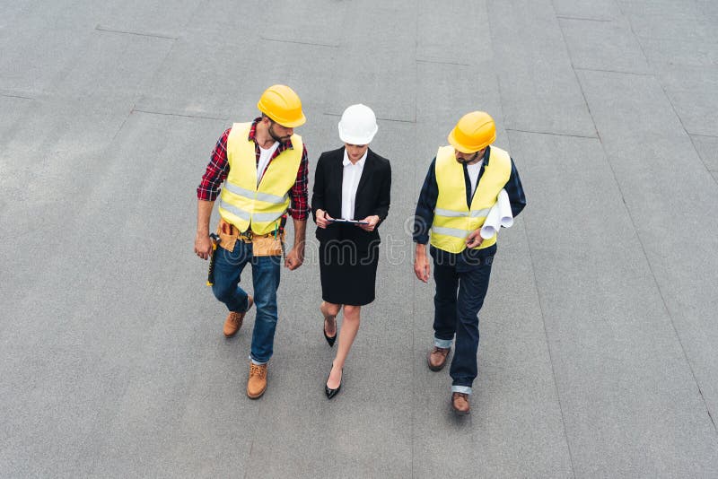 Overhead View of Female Architect and Male Workers in Helmets with ...